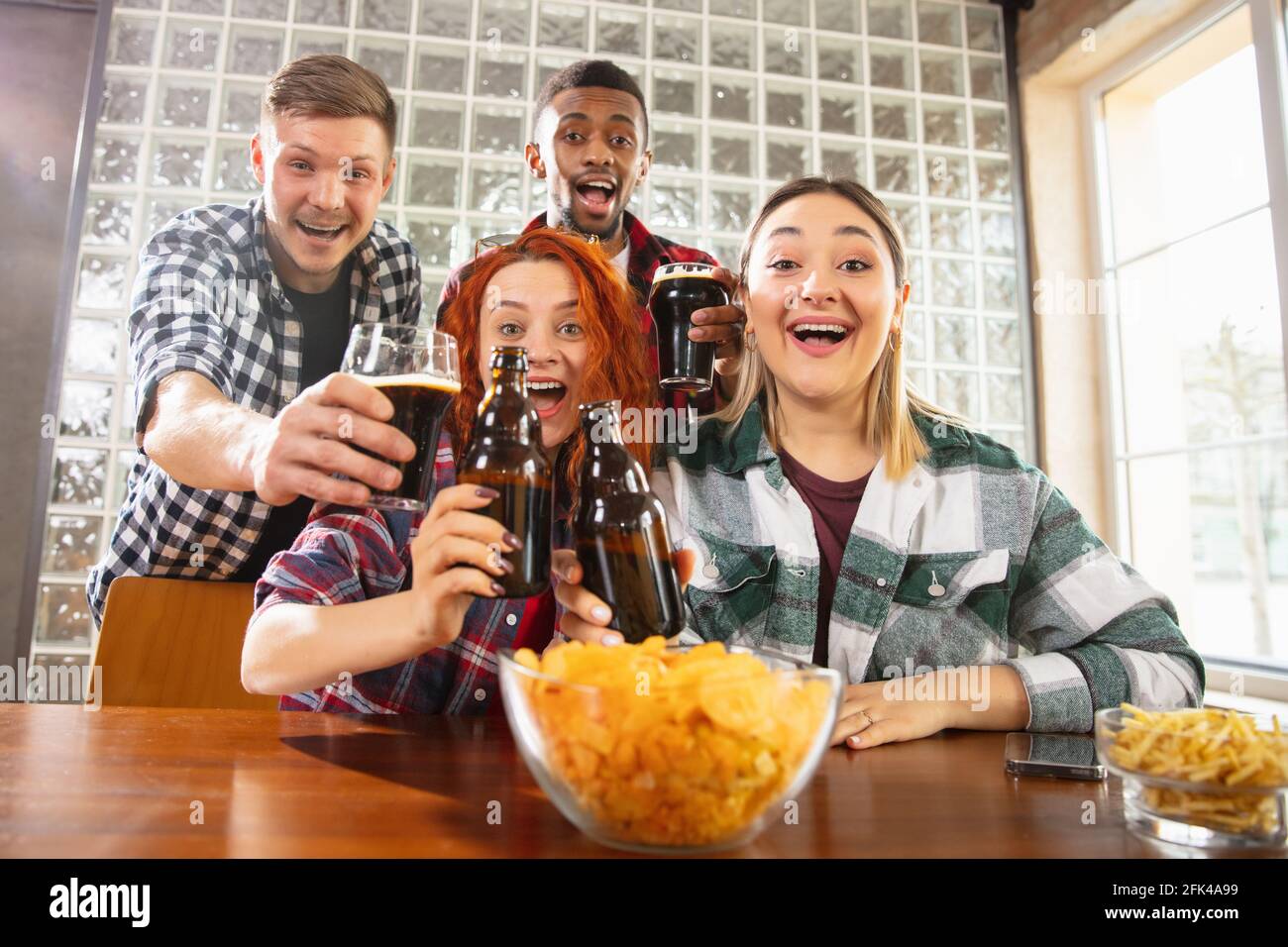 Group of friends watching sport match together. Emotional fans cheering ...