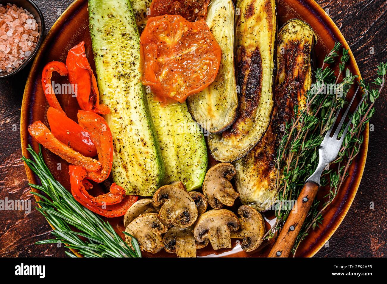 Grilled mix vegetables in a rustic plate. Dark background. Top view ...