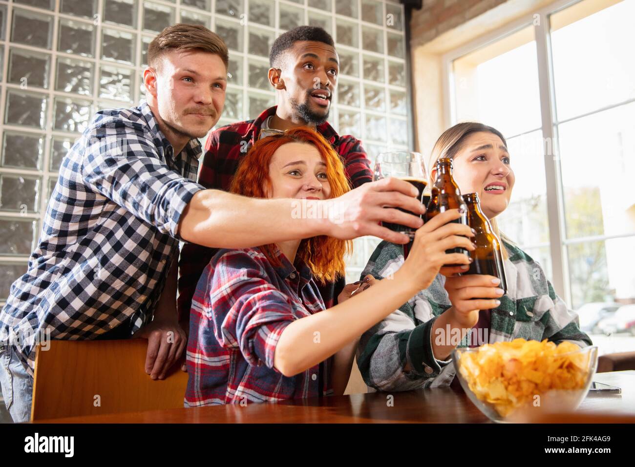 Group of friends watching sport match together. Emotional fans cheering ...