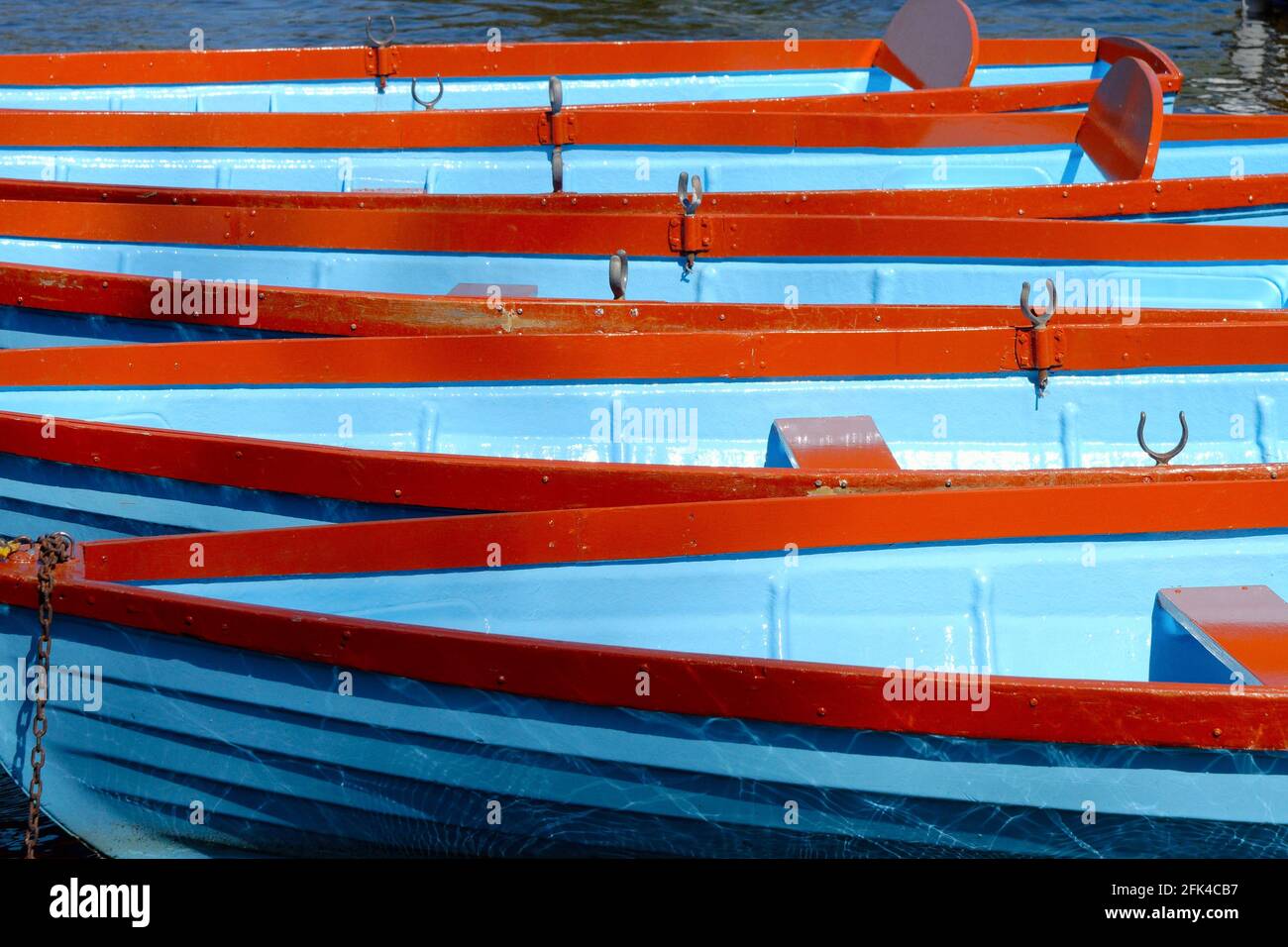 Close up of blue and red painted clinker built rowing boats creating ...