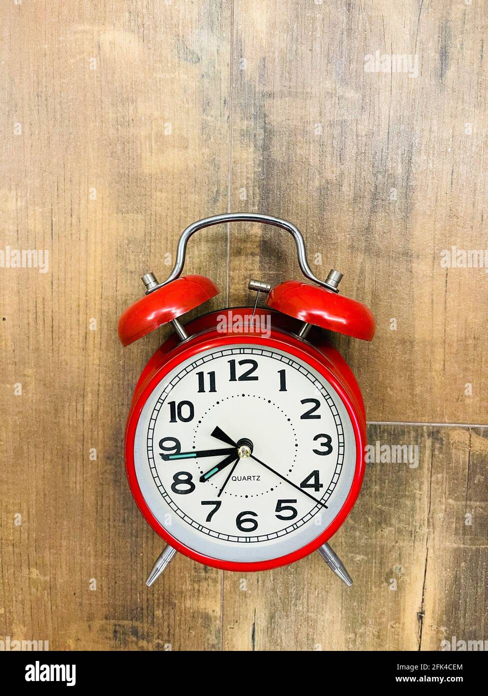 Red alarm clock on wooden floor. Time concept Stock Photo - Alamy