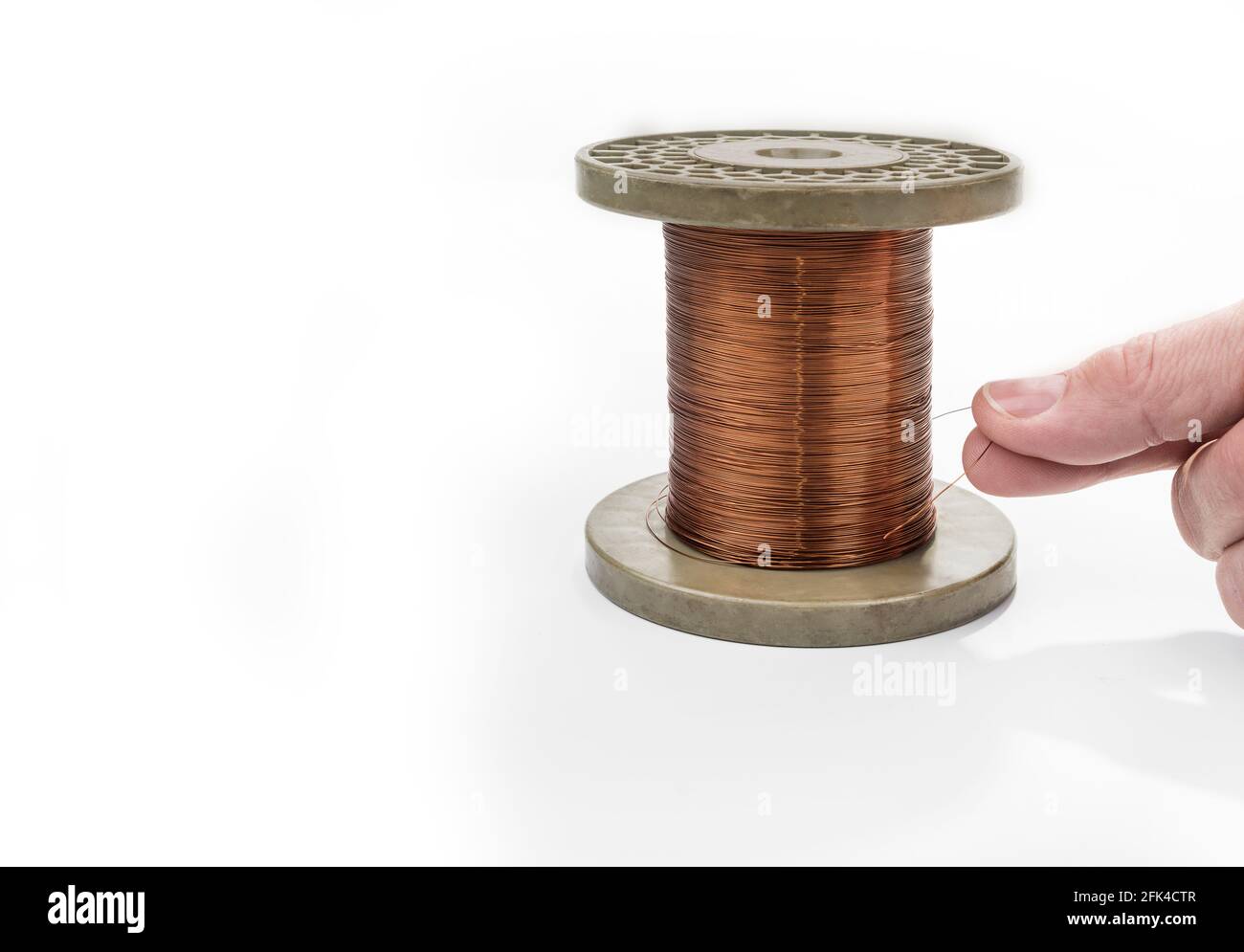 Copper wire on a reel on a white background Stock Photo - Alamy