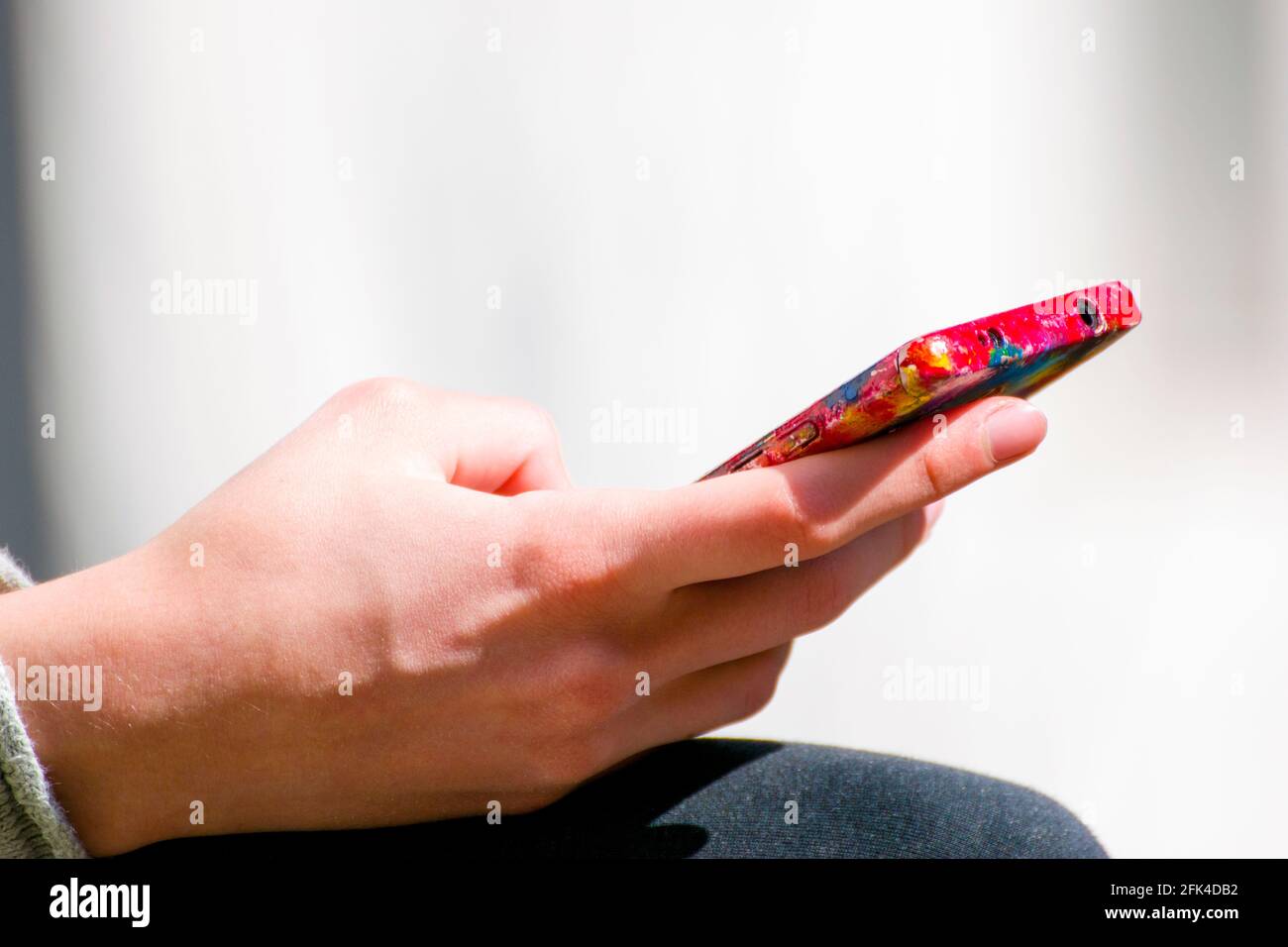 A smart phone held in hands by a girl. Face is not visible. Only one ...