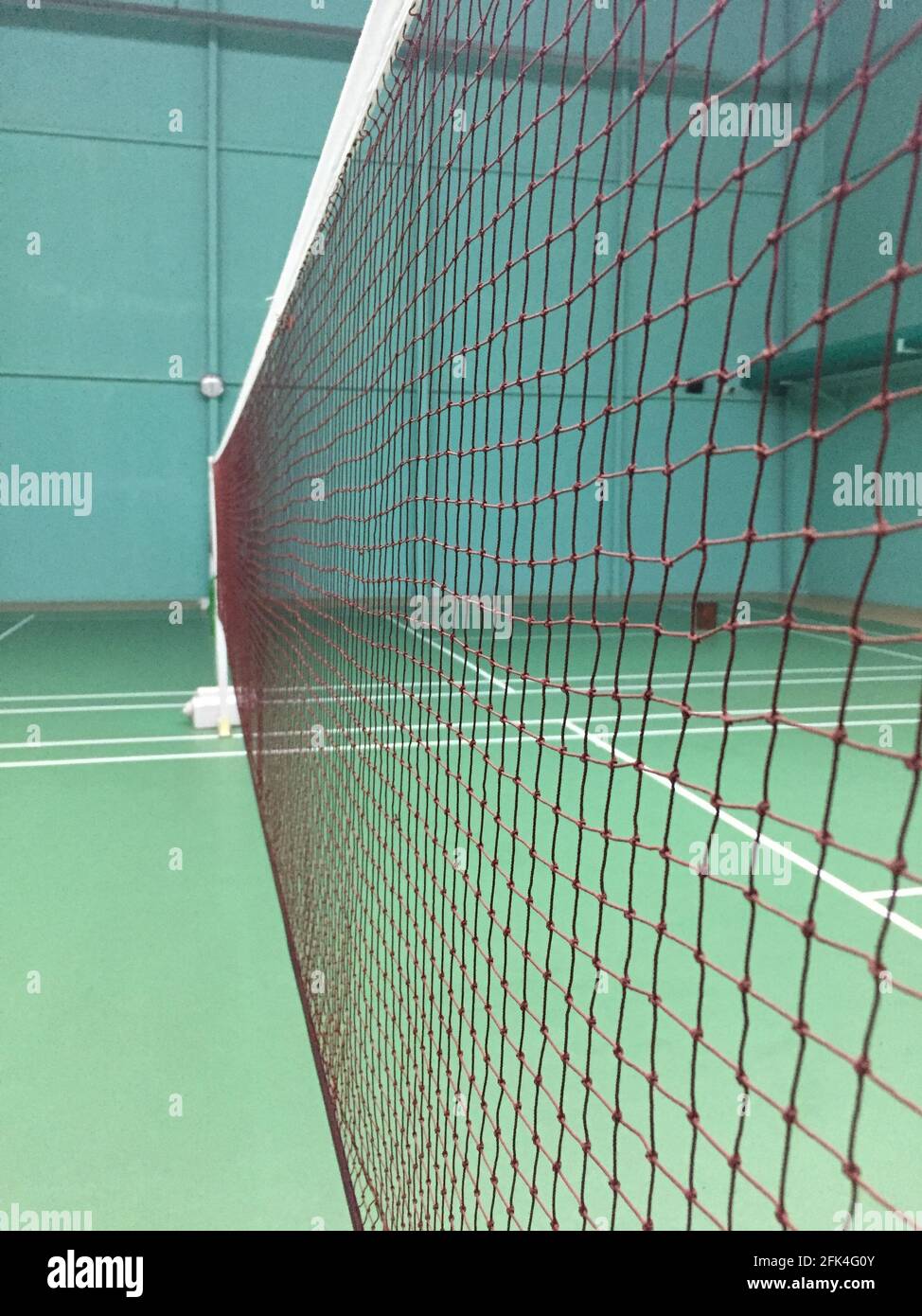 Vertical shot of the net of an empty indoor badminton court Stock Photo ...
