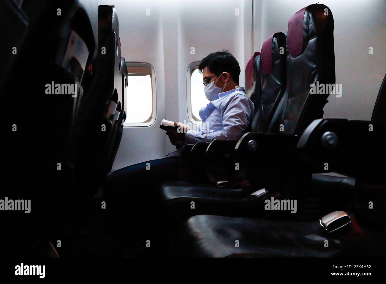 A passenger wearing a face mask as a precaution against the spread of ...