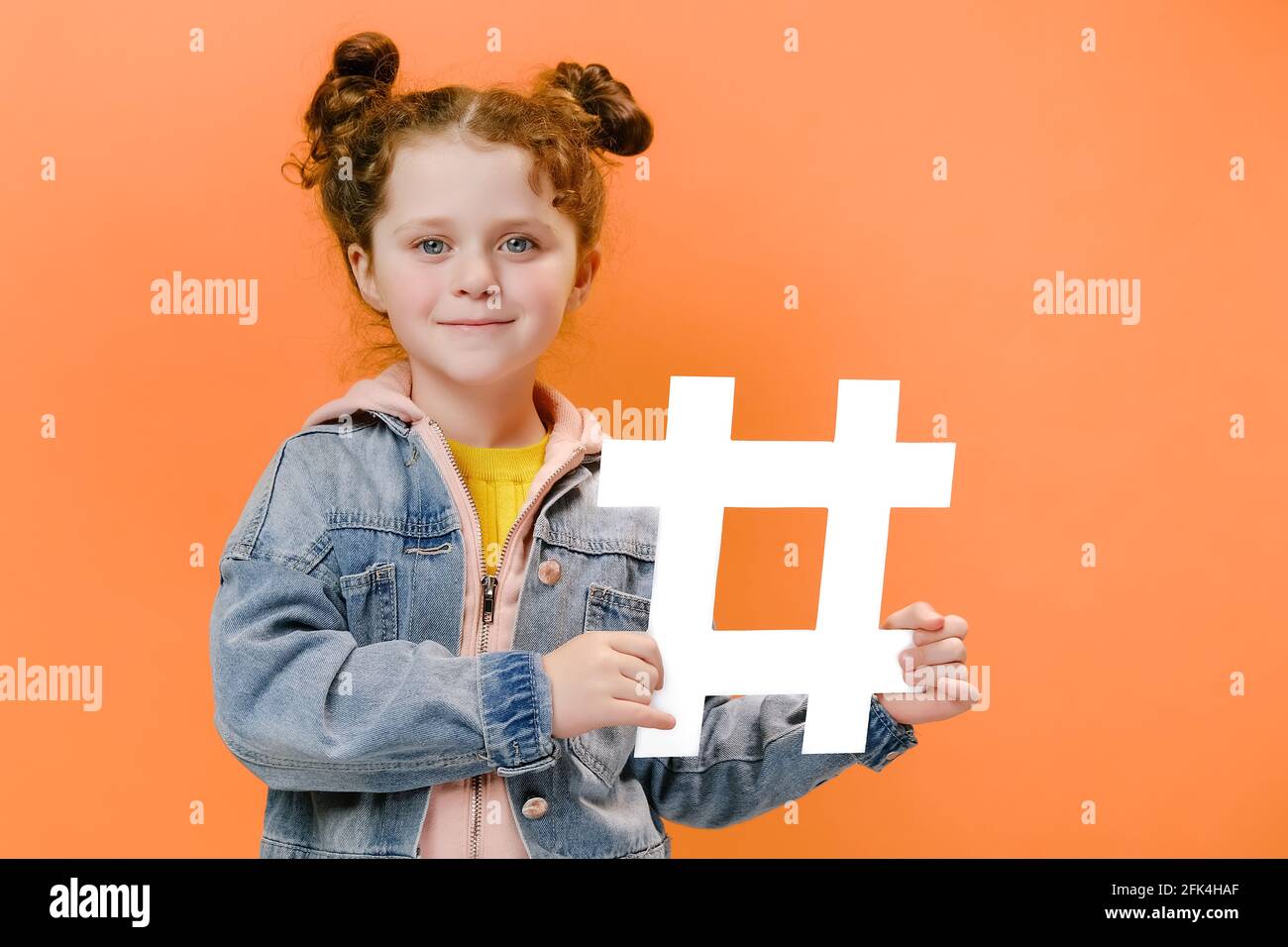 Happy cute little girl child holding big hashtag symbol, smiling ...