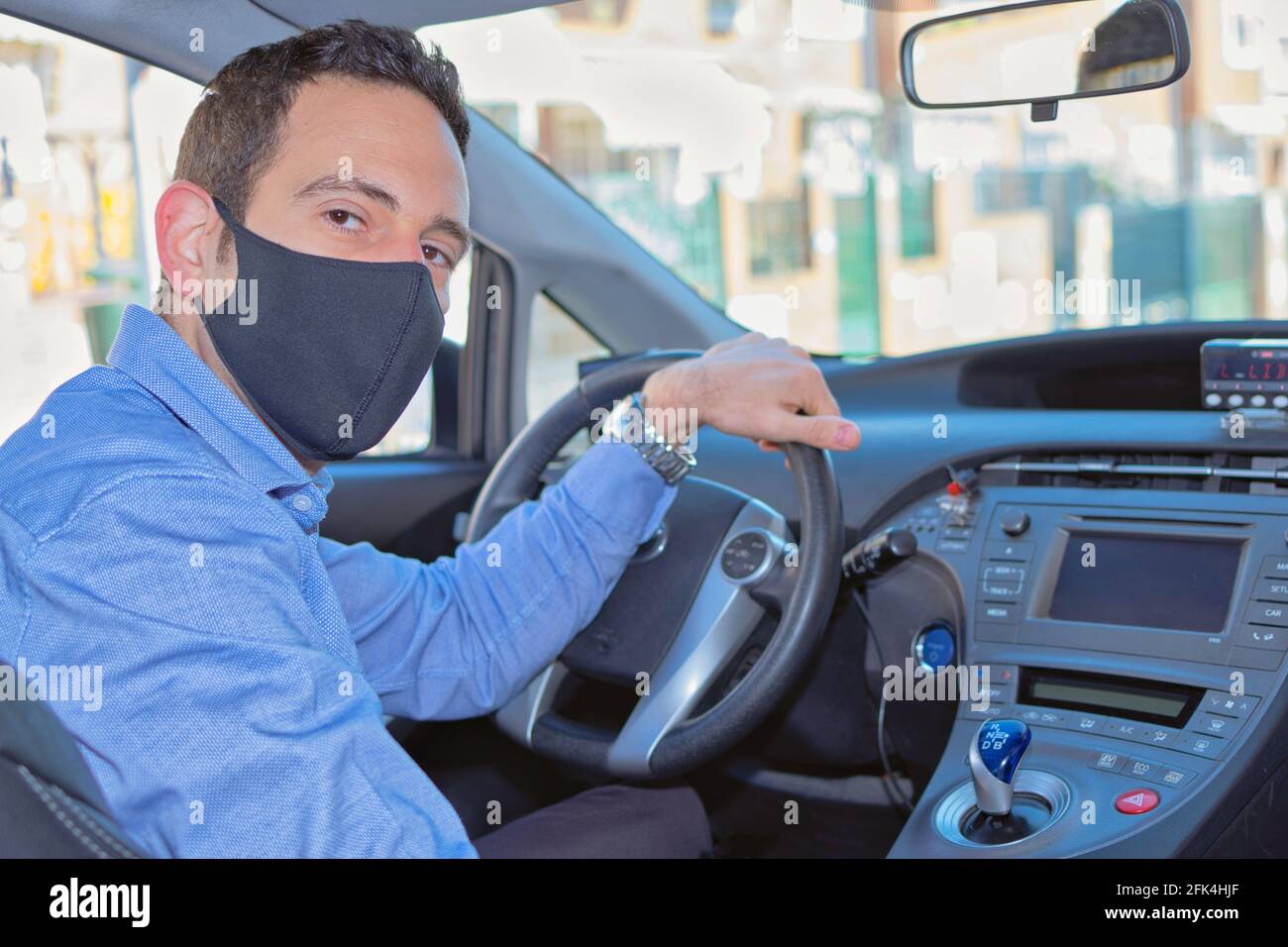 Caucasian male taxi driver wearing a medical mask to be protected from ...