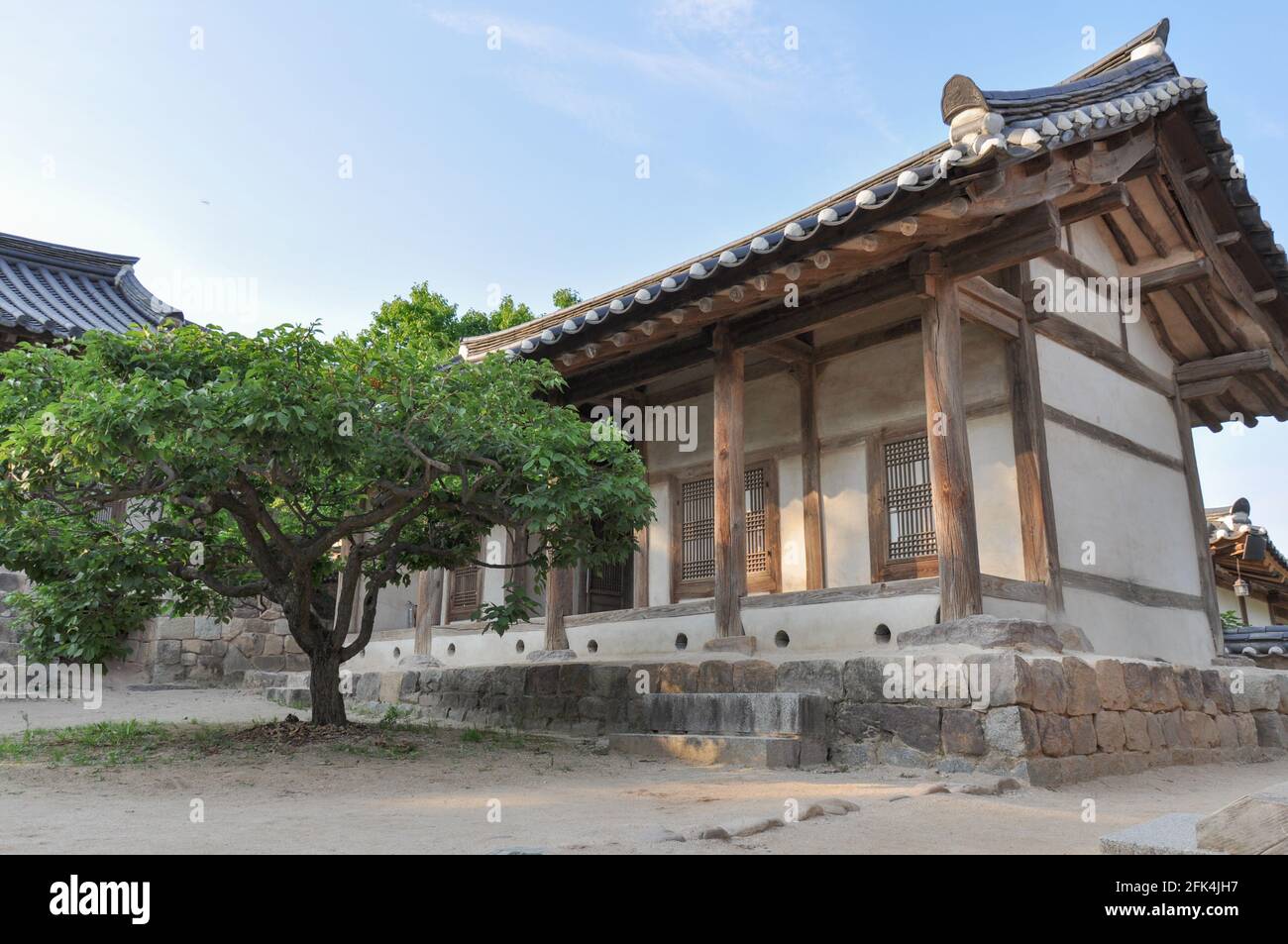 Courtyard with small tree and traditional korean buildings from it’s ...