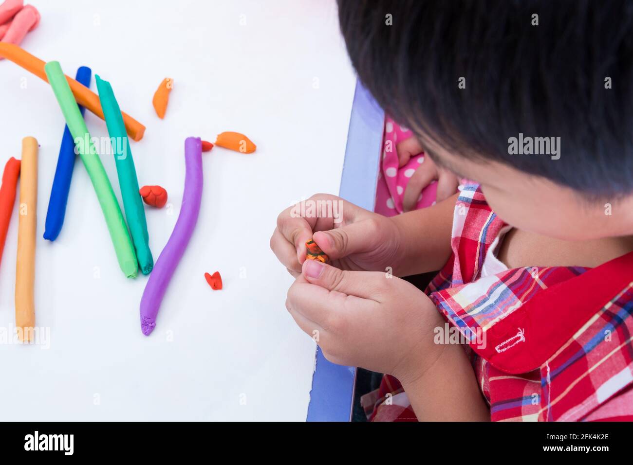 Little boy creating toys from play dough. Child moulding modeling clay ...