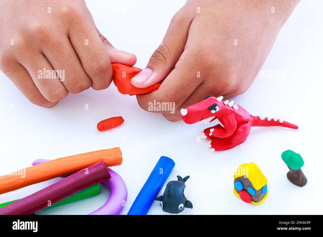 Child playing and creating toys from play dough. Child molding modeling ...