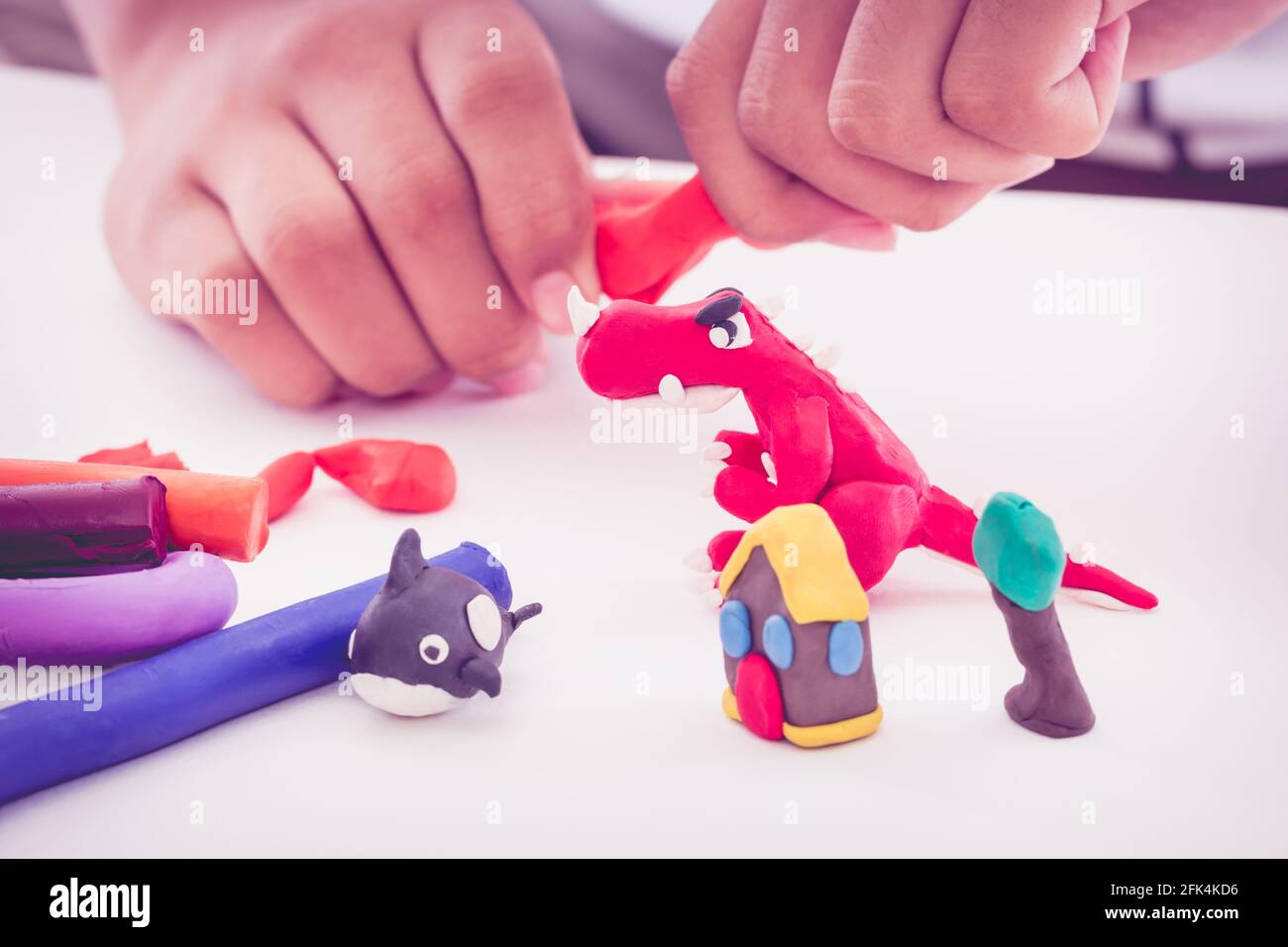 Child playing and creating toys from play dough. Child molding modeling ...