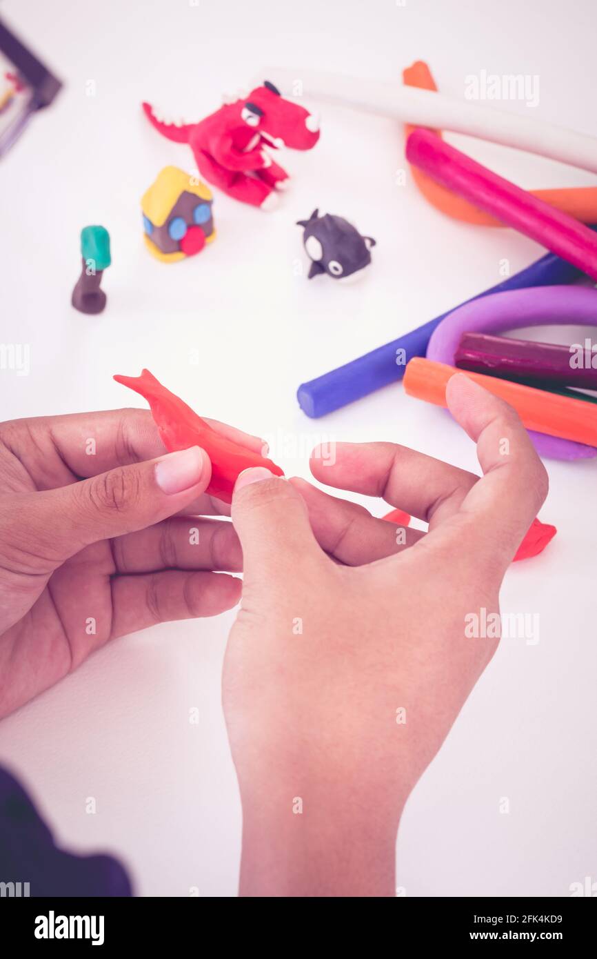 Child playing and creating toys from play dough. Child molding modeling ...