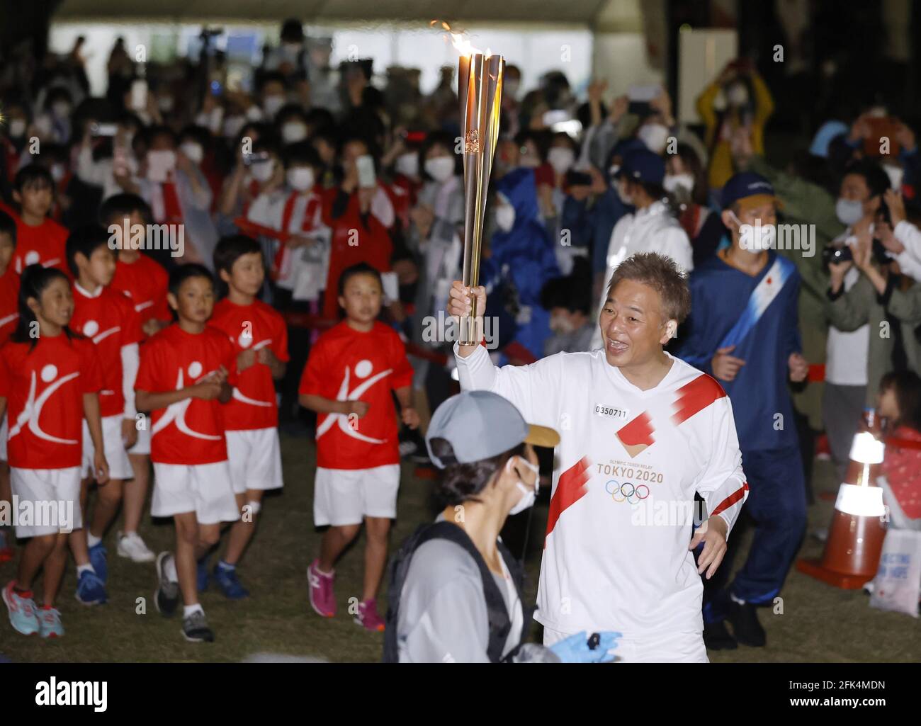 Ibusuki, Japan. 28th Apr 2021. TV personality Toshiaki Megumi runs in the Tokyo Olympic torch ...
