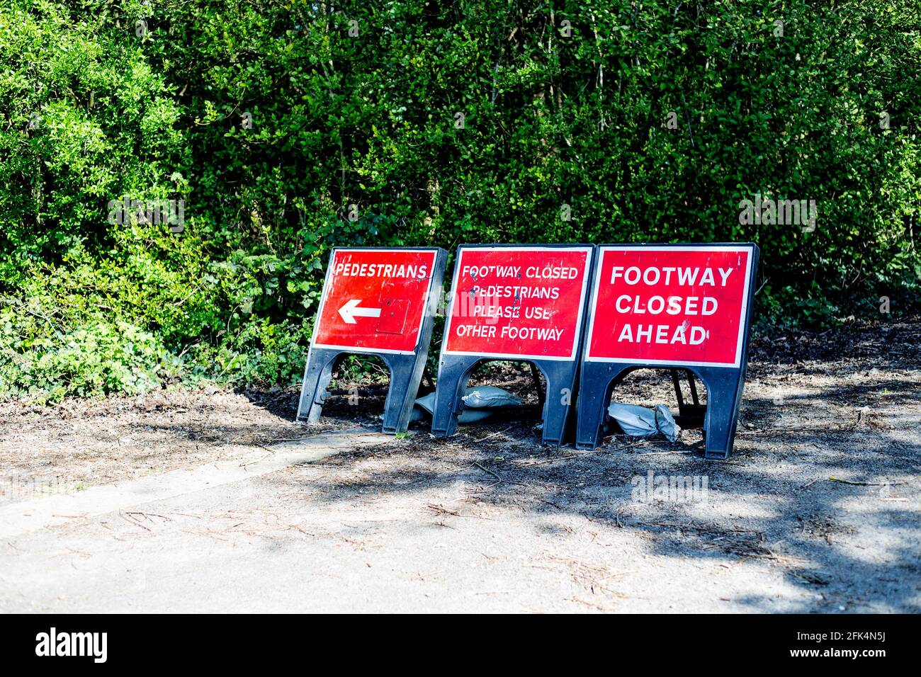 Three red signs warning pedestrians of a closed footway in Farmoor ...