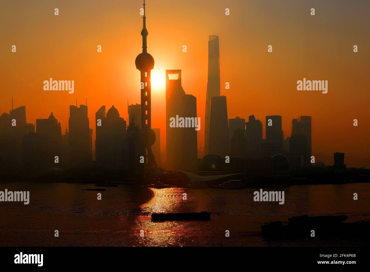 The sun rises behind the magnificent skyline of Shanghai creating ...