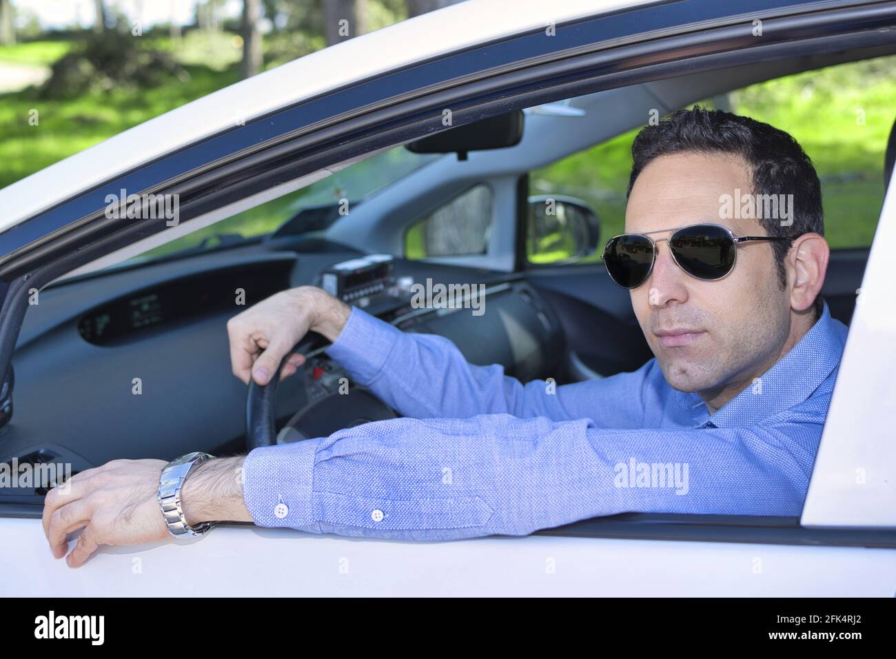 Caucasian male cab driver with sunglasses waiting for the customer ...