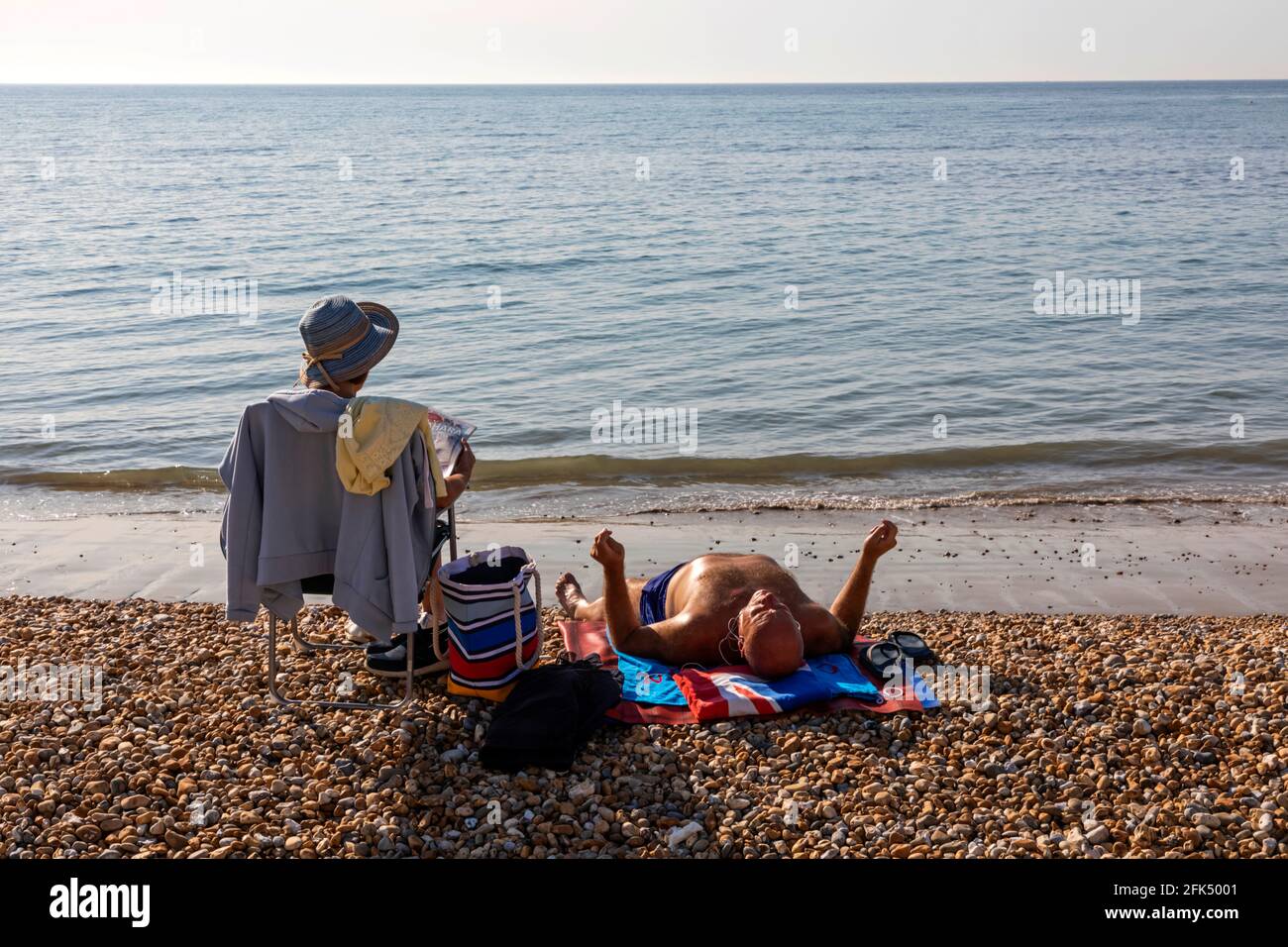 Couple sunbathing on the beach hi-res stock photography and images - Alamy