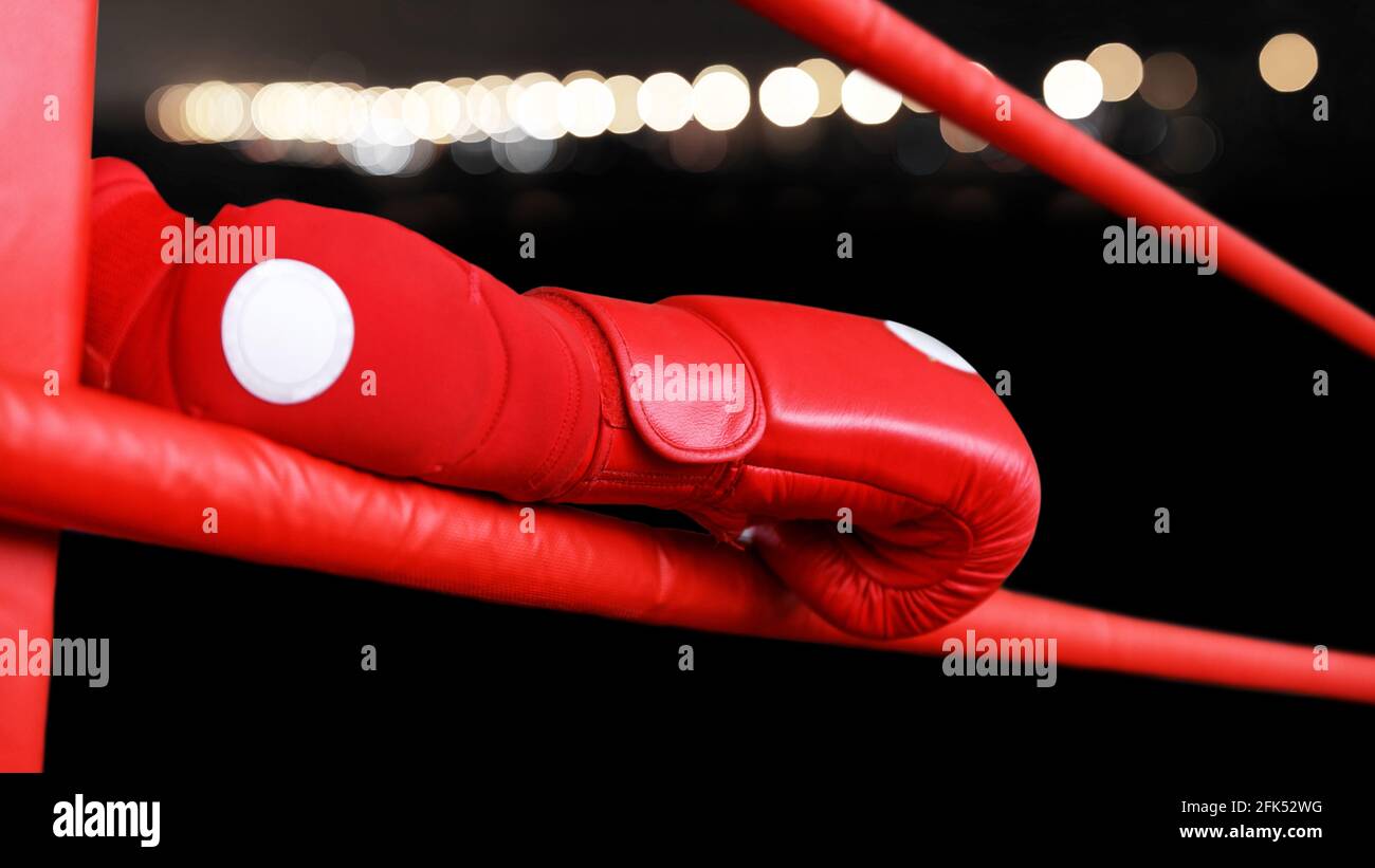 Closeup boxer hand in red glove on the ring rope. Shallow focus and ...