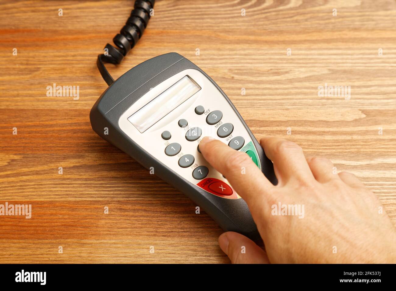 Human hand dials the code on the keypad of the payment terminal on ...