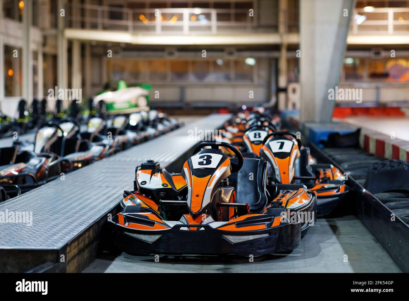 Kart cars parked one by one on indoor go-kart racing track in ...