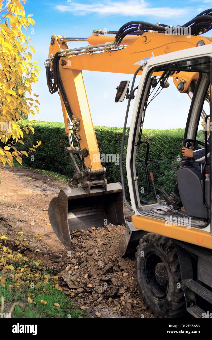 Preparation of a road by a backhoe before tarring Stock Photo - Alamy