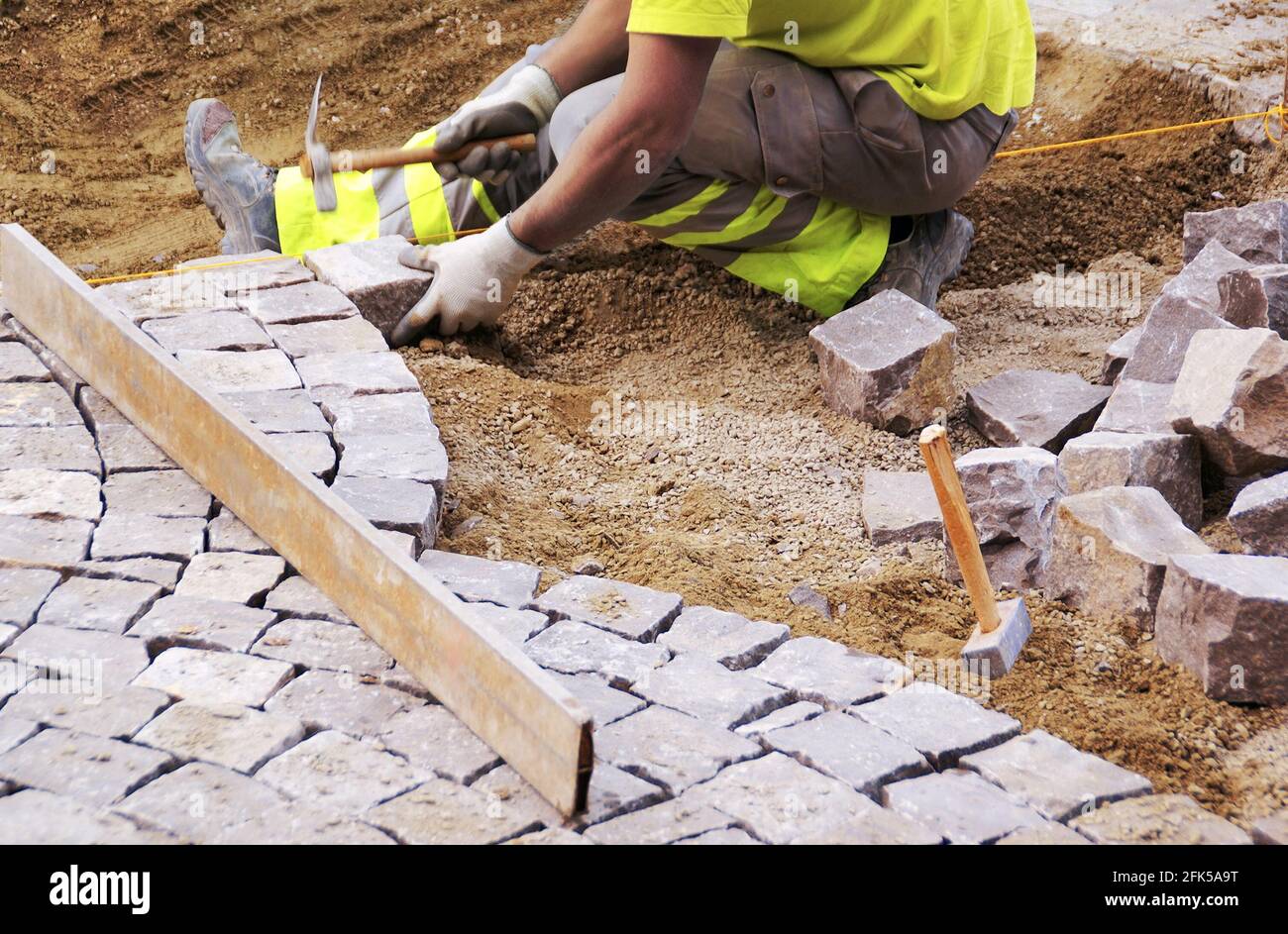 Paving a street by workers in a traditional way Stock Photo - Alamy