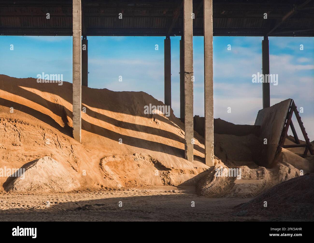 A large pile of sand under a canopy of slate storage on industrial ...