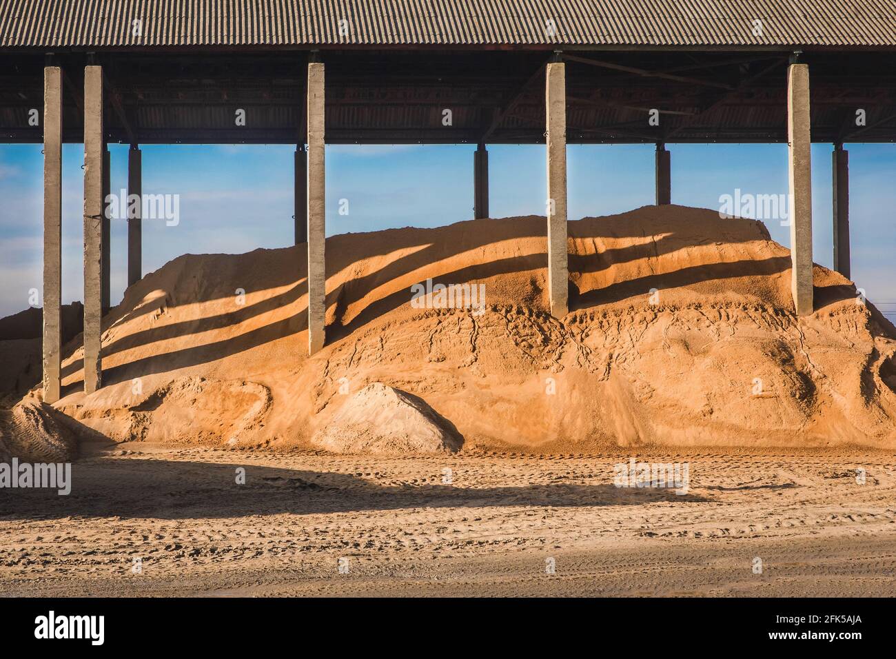 A large pile of sand under a canopy of slate storage on industrial ...