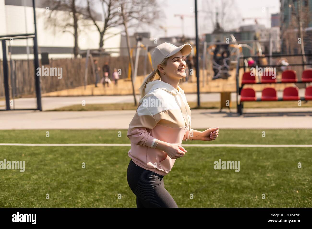 Happy and Smiling Fitness WomanJogging in a Stadium. She is Running ...