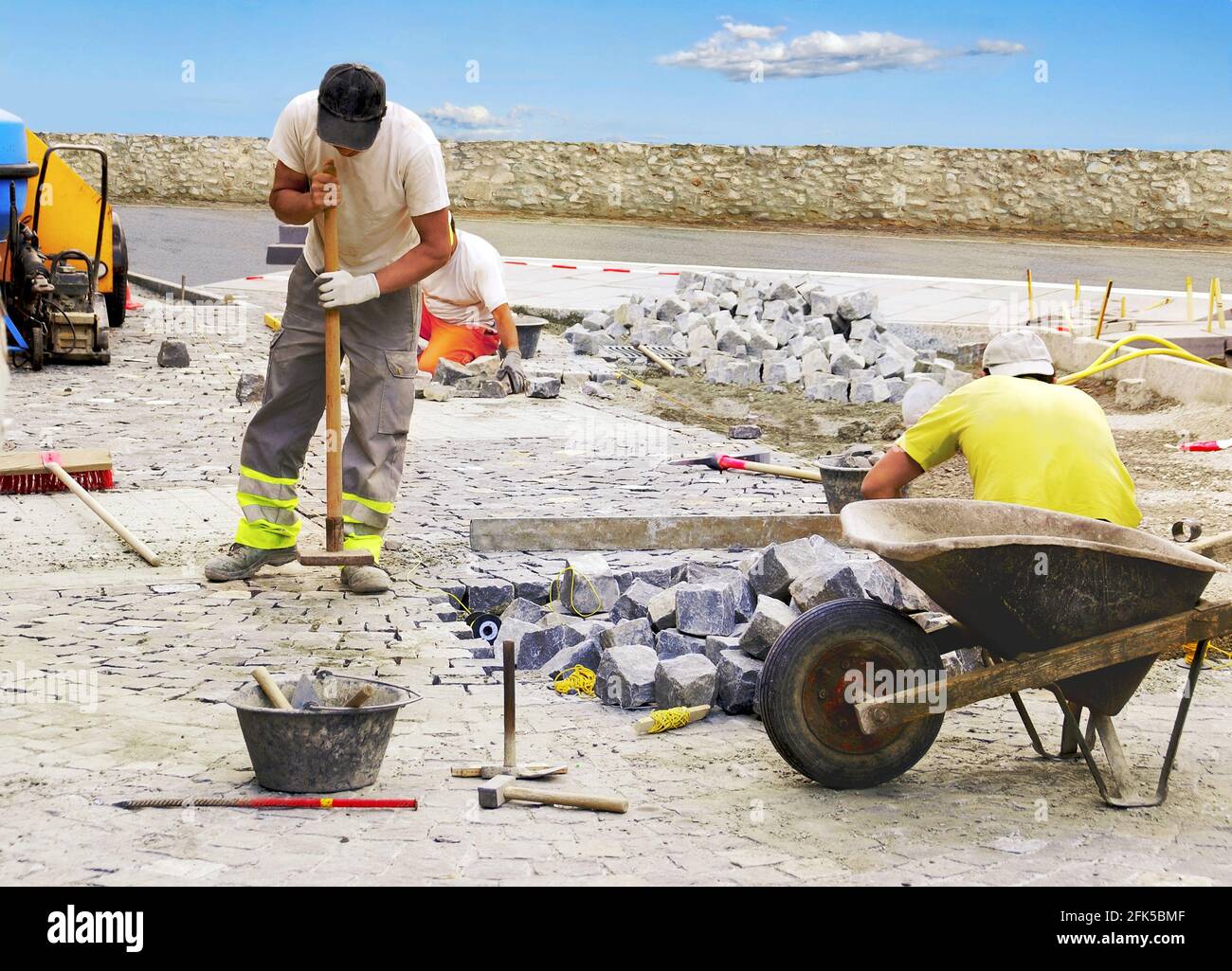 Paving a street by workers in a traditional way Stock Photo - Alamy