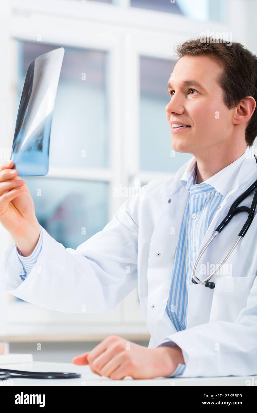 Radiology - young doctor looking at a tomography x-ray picture of a ...