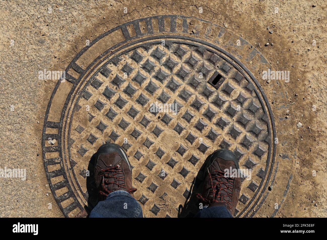 Metal cap on the road after rain in close up Stock Photo - Alamy