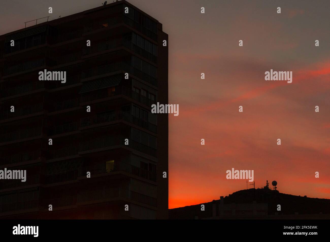 Beautiful shot of fiery red sunset seen through residential building ...