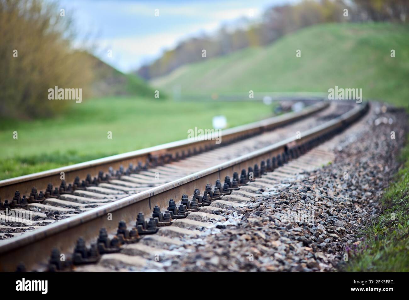 Selective focus railway track turns and twists between hills. Empty ...