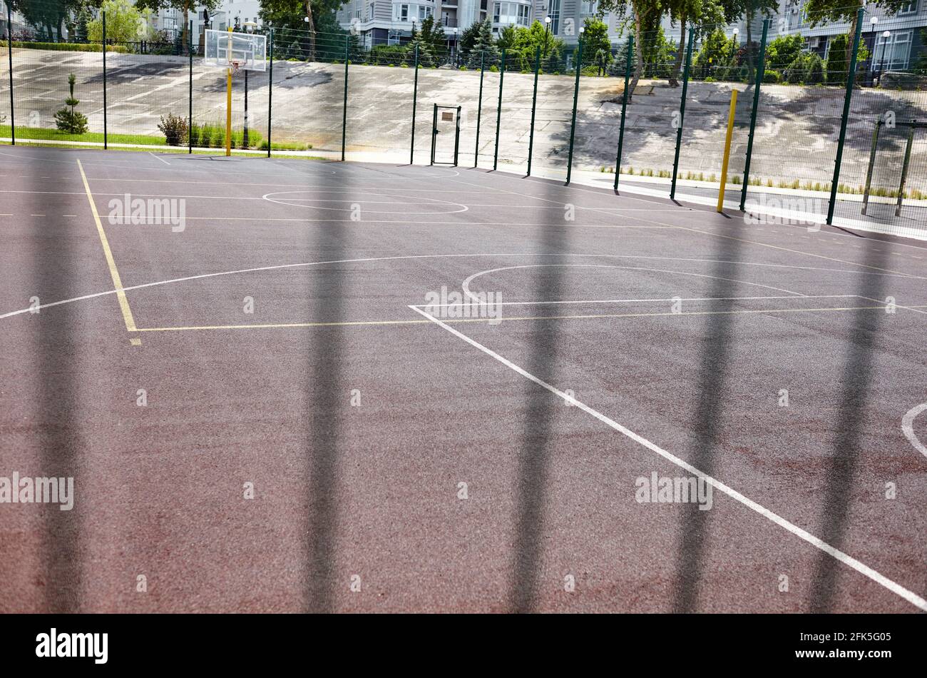 Basketball court from behind fence. Basketball hoop in the city park ...