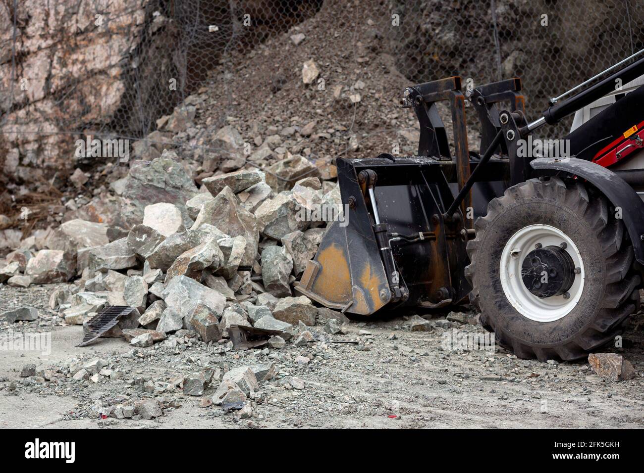 Bagger clean the aftermath of a stone landslide Stock Photo - Alamy