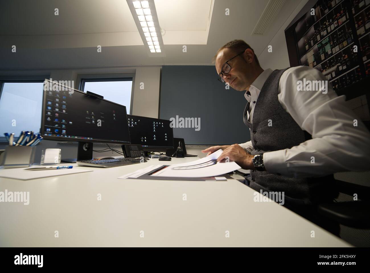 A manager - Caucasian male in his office sitting behind the desk ...
