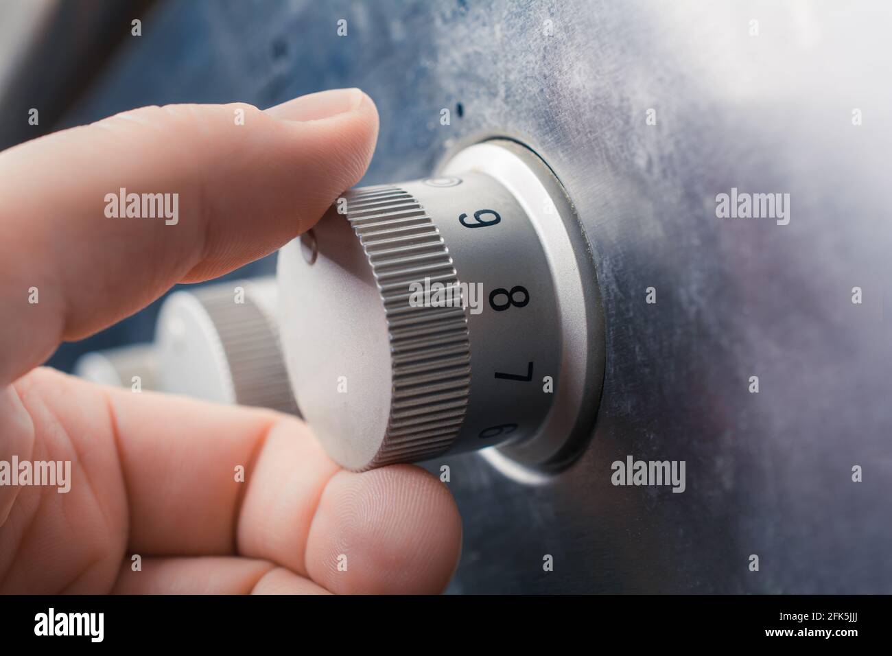 Male Hand On Stove Controls With Heat Level 0 Stock Photo - Alamy