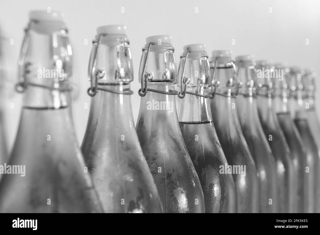 Black and white photo of a row of flip top bottles of home made cider ...