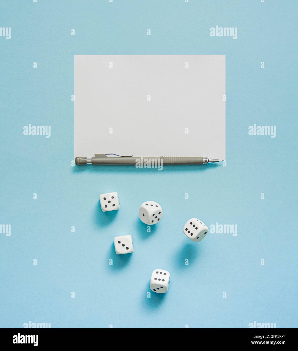 Yahtzee game in progress. Rolling dice, pencil and score sheet on a ...