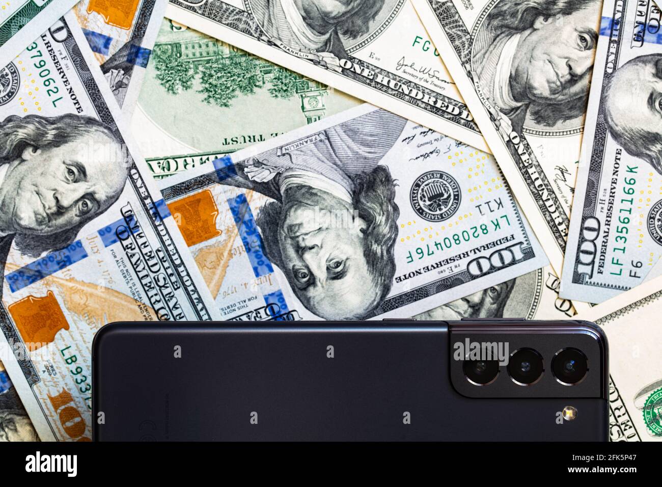 Phantom Grey smart phone on 100 dollar banknotes background Stock Photo ...