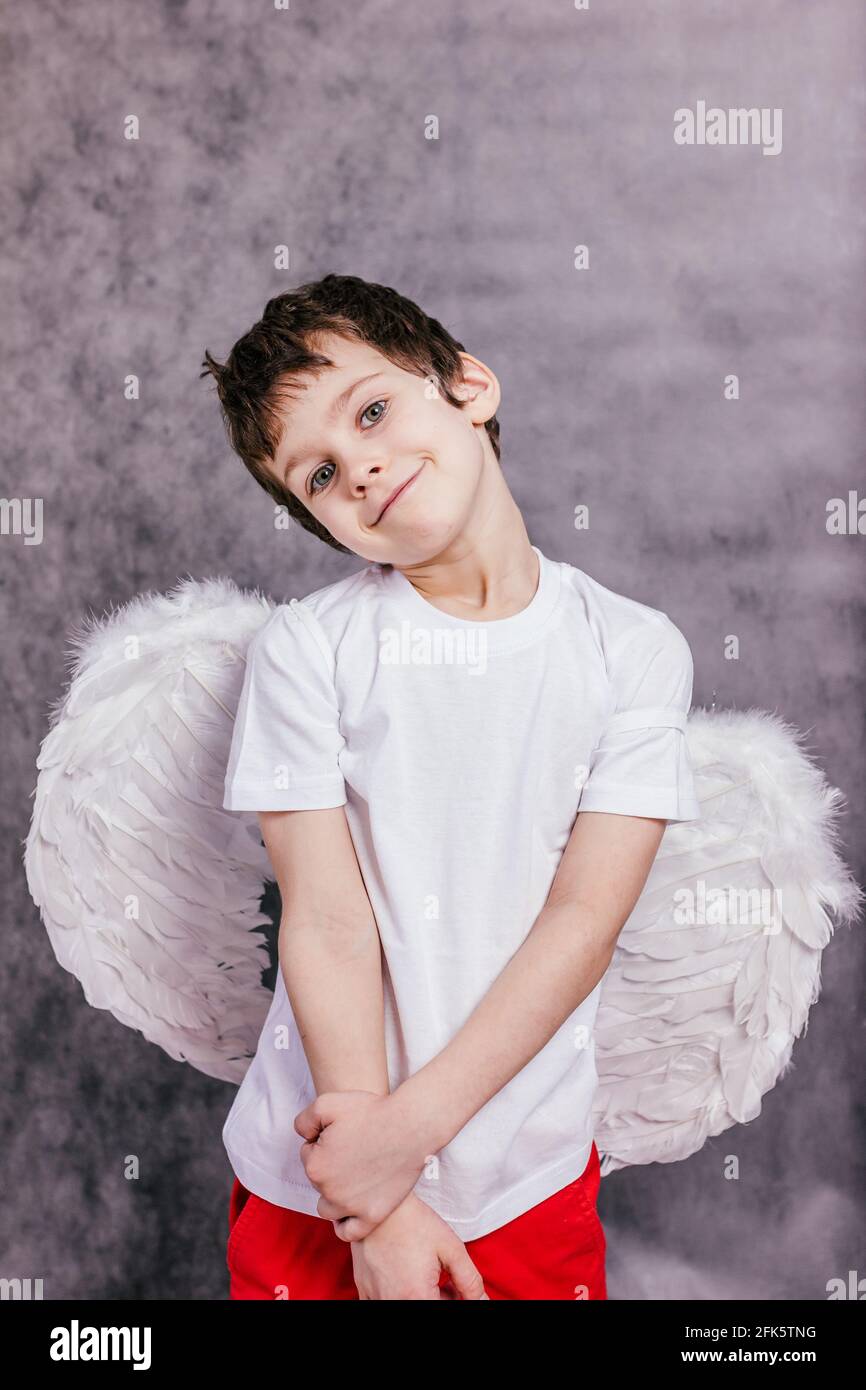 A child wearing angel wings and looking upwards Stock Photo - Alamy