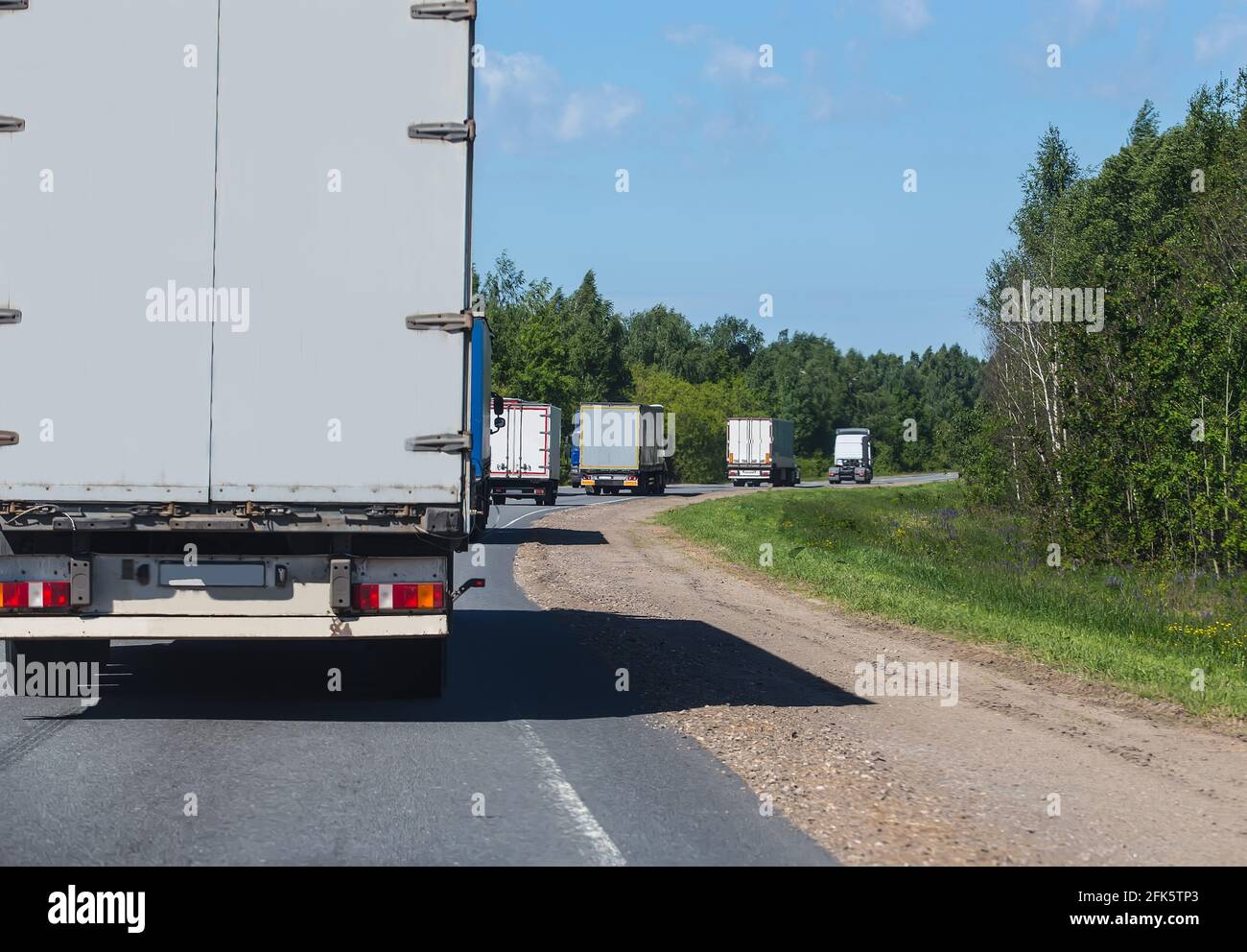 escort of trucks moves on road Stock Photo - Alamy