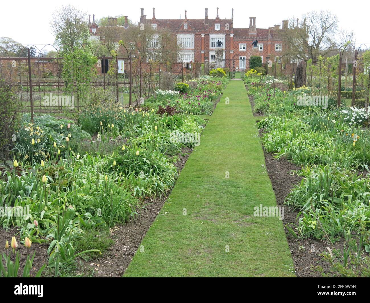 View of herbaceous borders with spring planting in the gardens designed ...