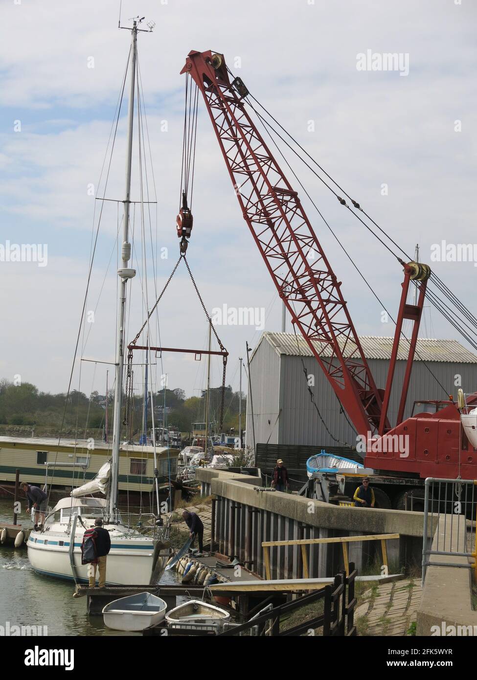 View of a large red crane and boats in the traditional working Melton ...