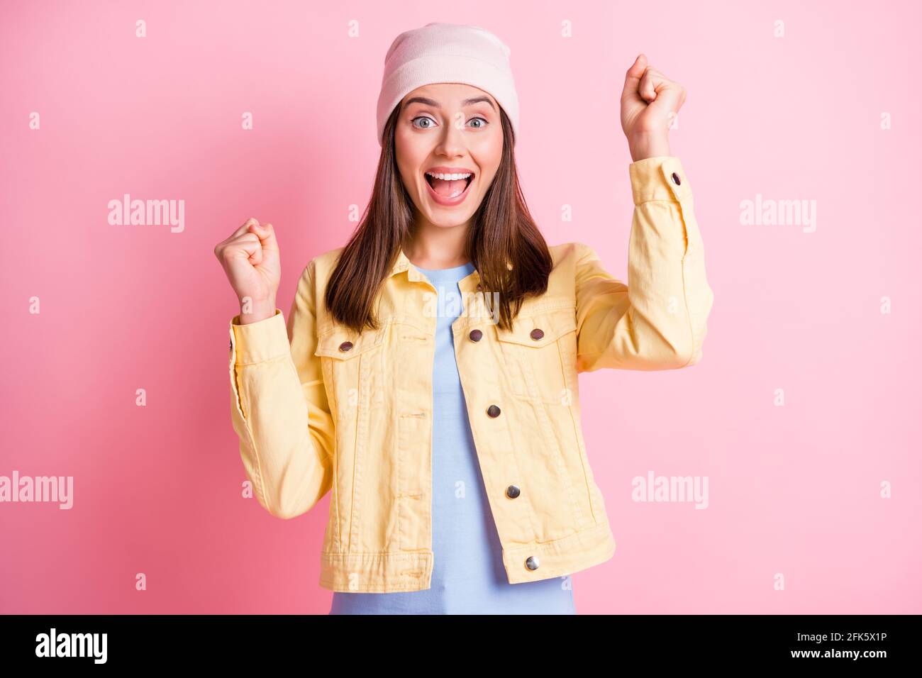 Photo of lucky charming young woman dressed casual clothes cap rising ...