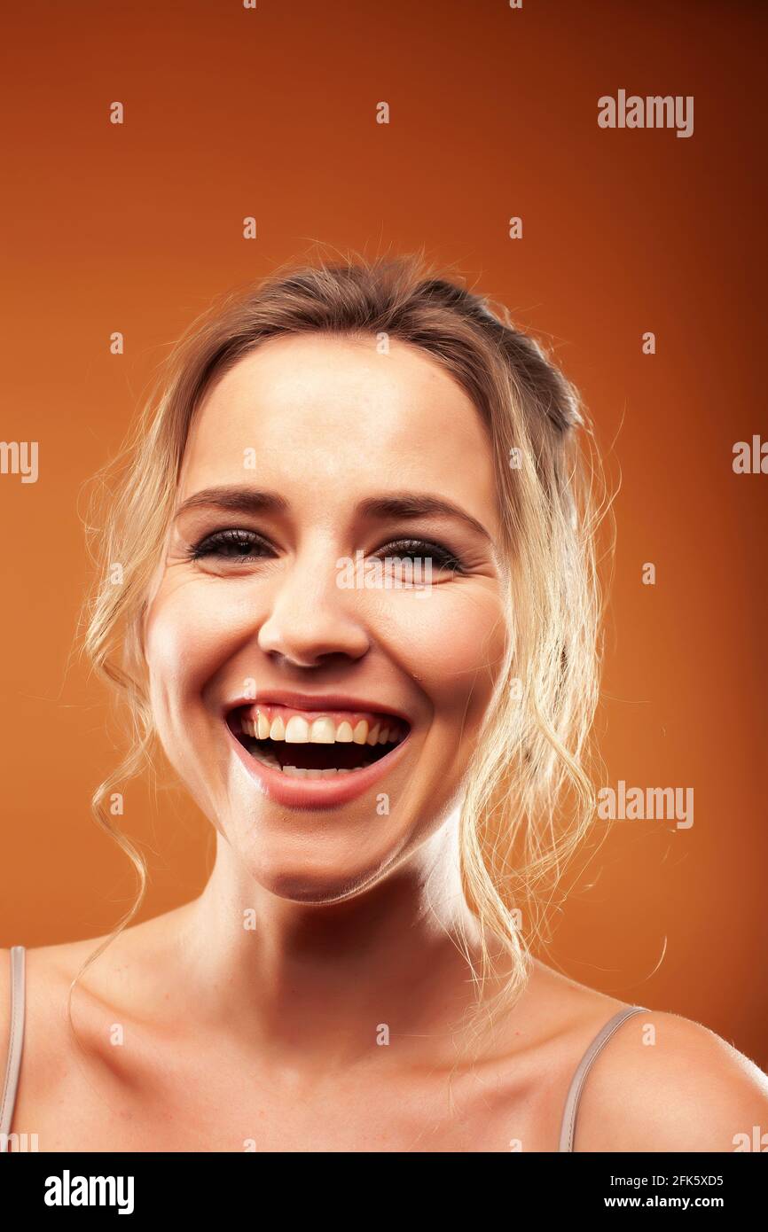 young pretty girl with blond hair posing cheerful on brown background ...
