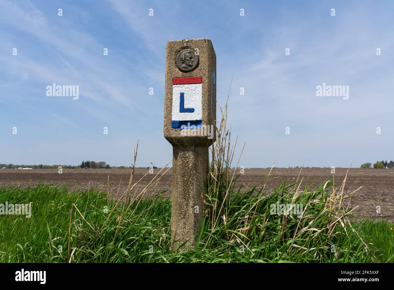 Original Lincoln Highway sign post in open field with blue skies and ...