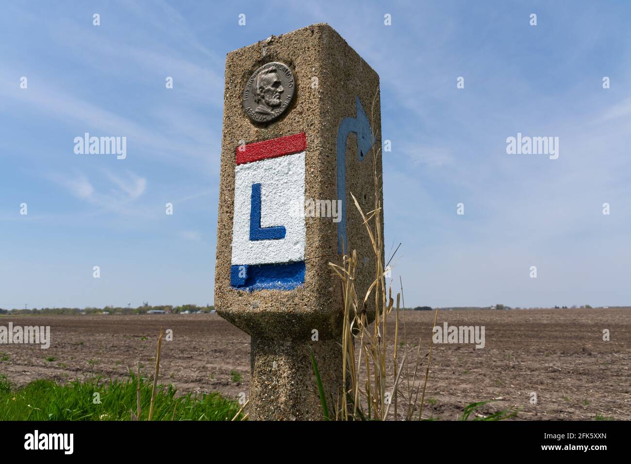 Original Lincoln Highway sign post in open field with blue skies and ...