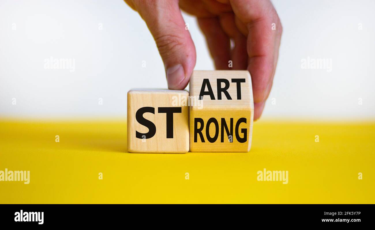 Start strong symbol. Businessman turns wooden cubes with words 'start ...